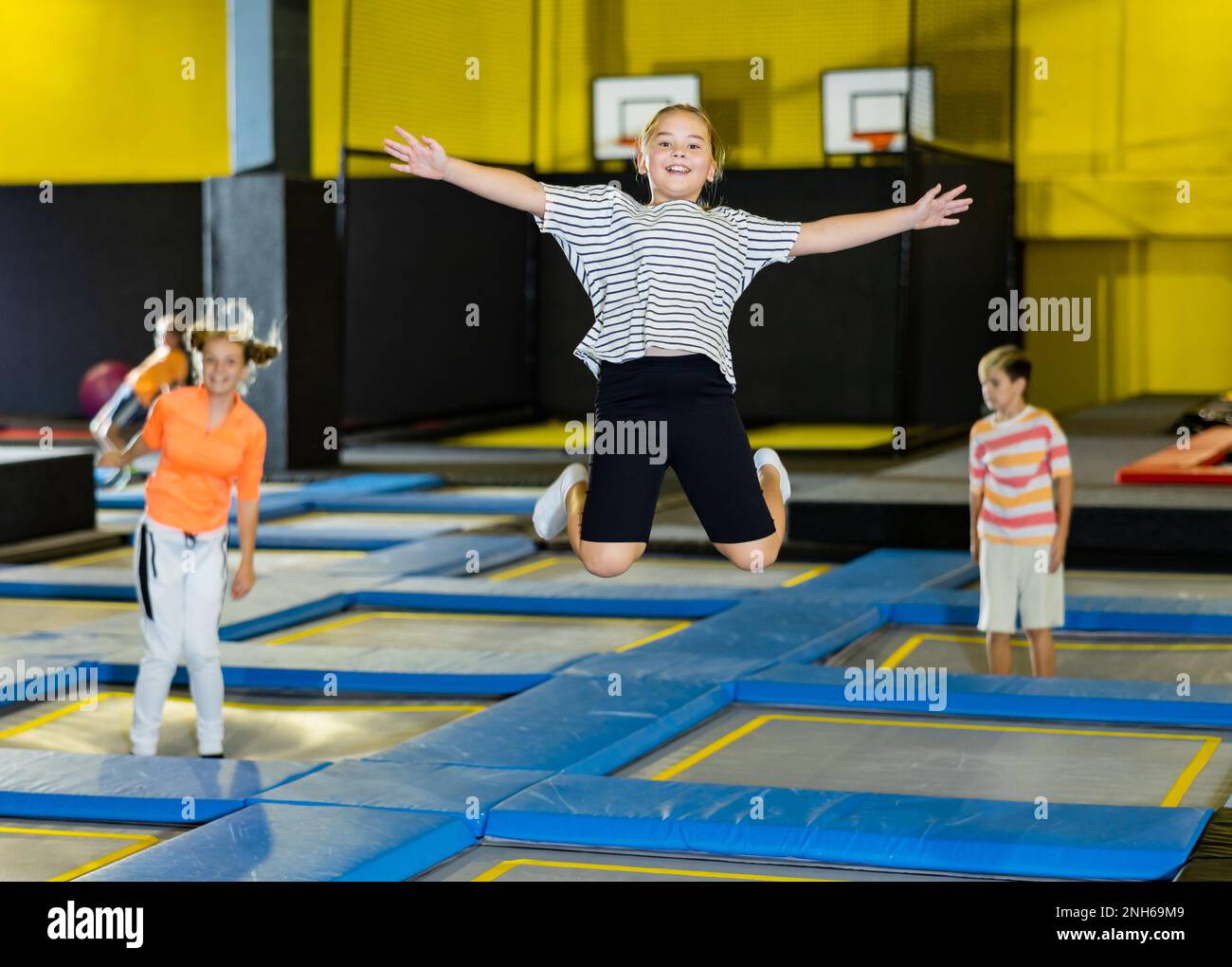 Tween girl having fun jumping in indoor trampoline arena Stock Photo ...