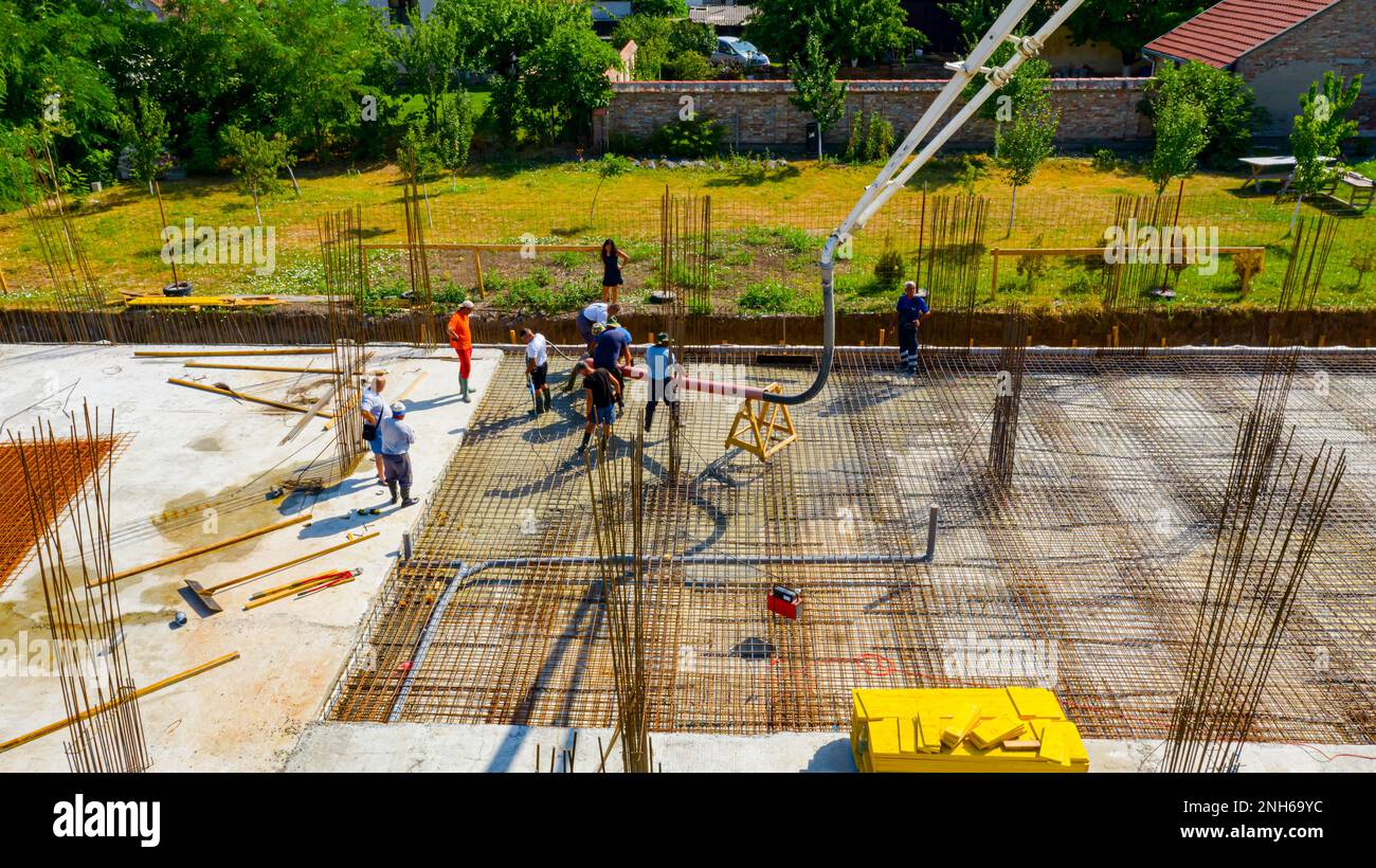 Aerial view construction worker is directing the pump tube as pouring ...