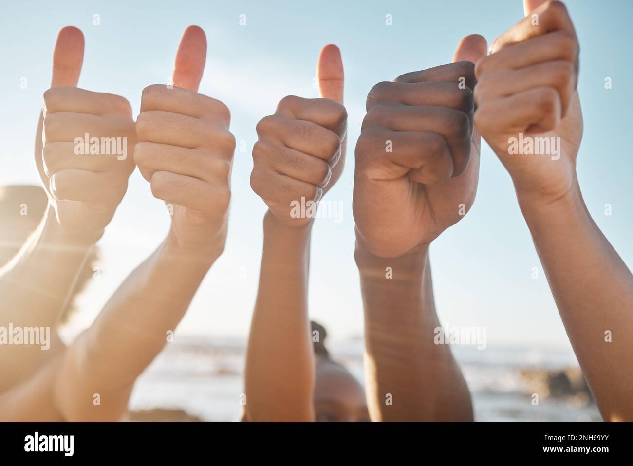 People, hands and diversity with thumbs up at beach for good job ...