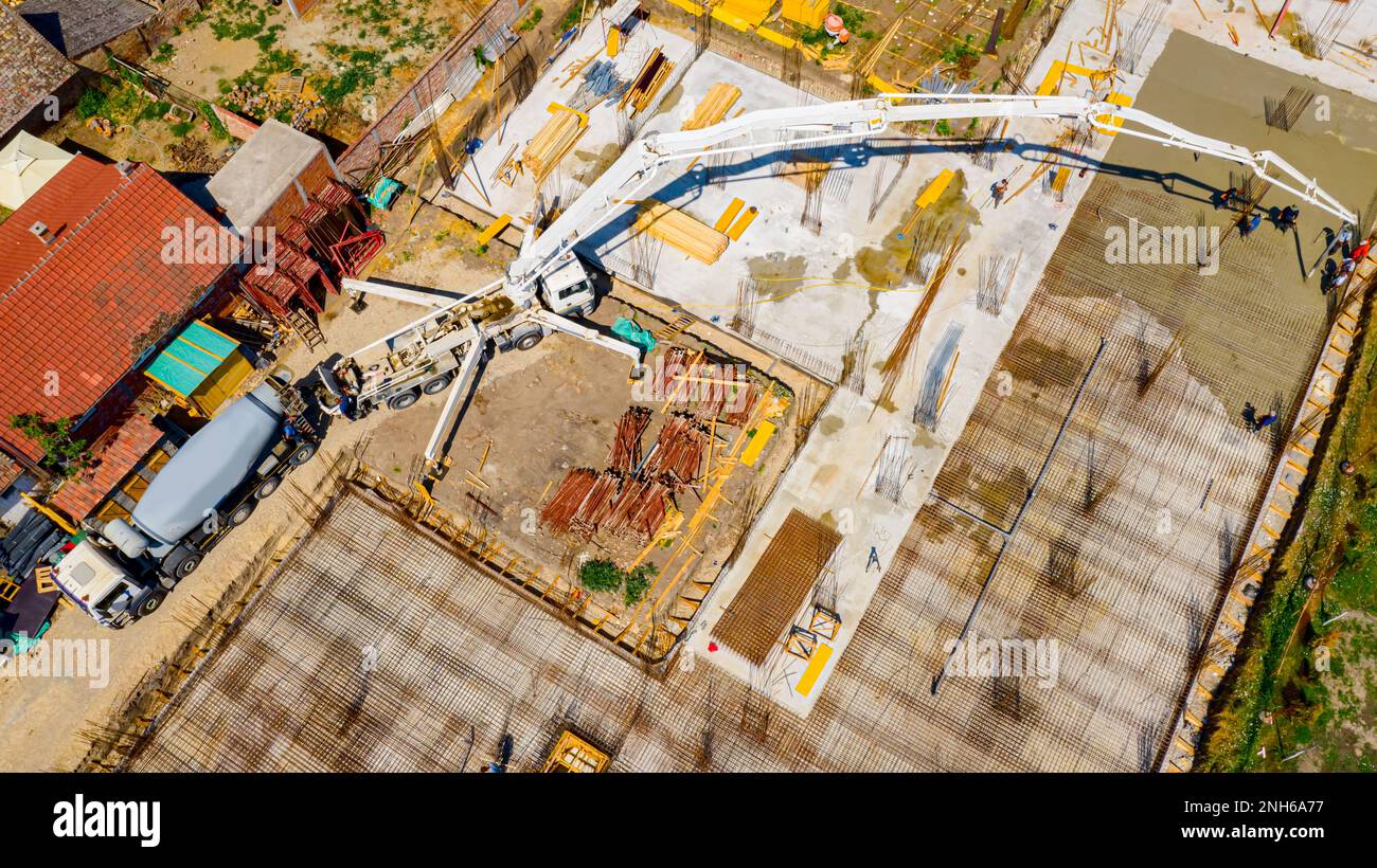 Aerial view construction site, mixer truck pouring concrete into pump ...