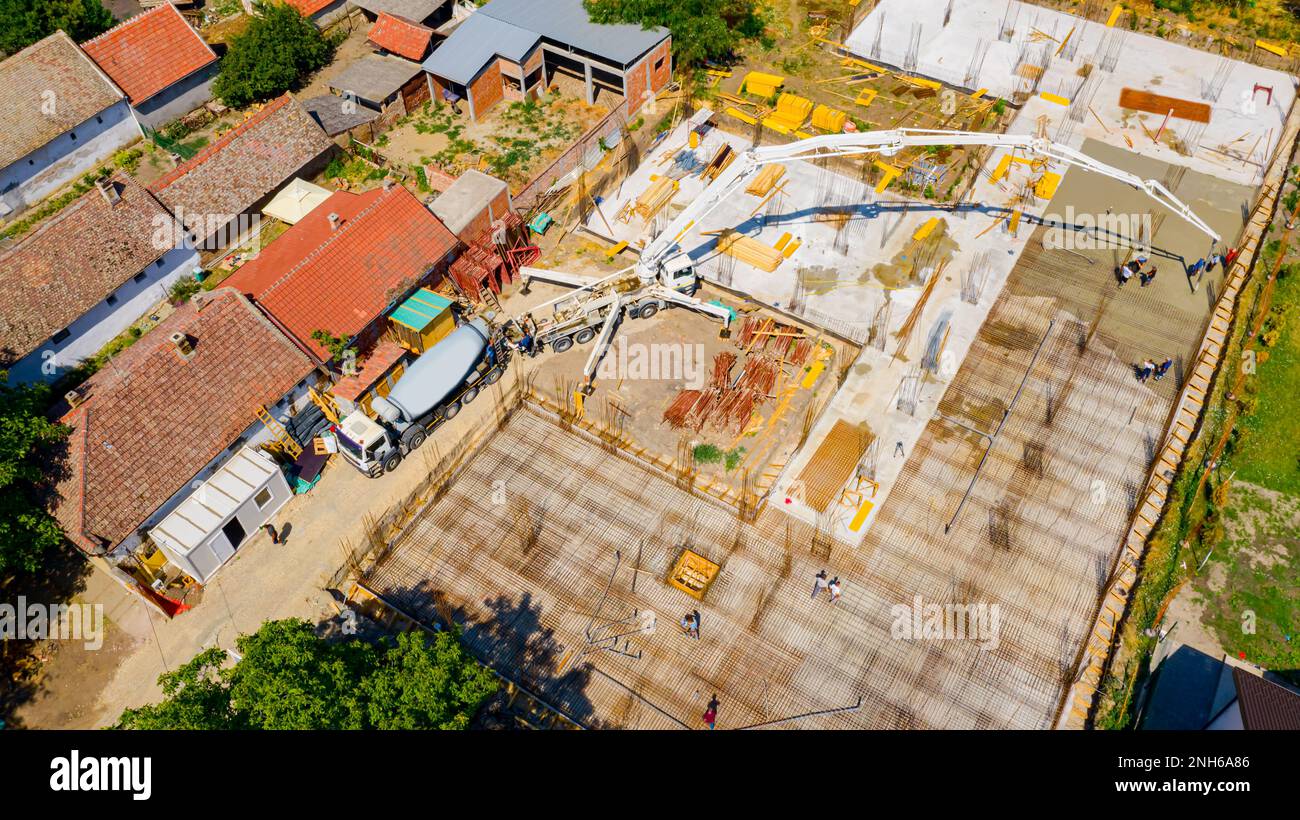 Aerial view construction site, mixer truck pouring concrete into pump ...