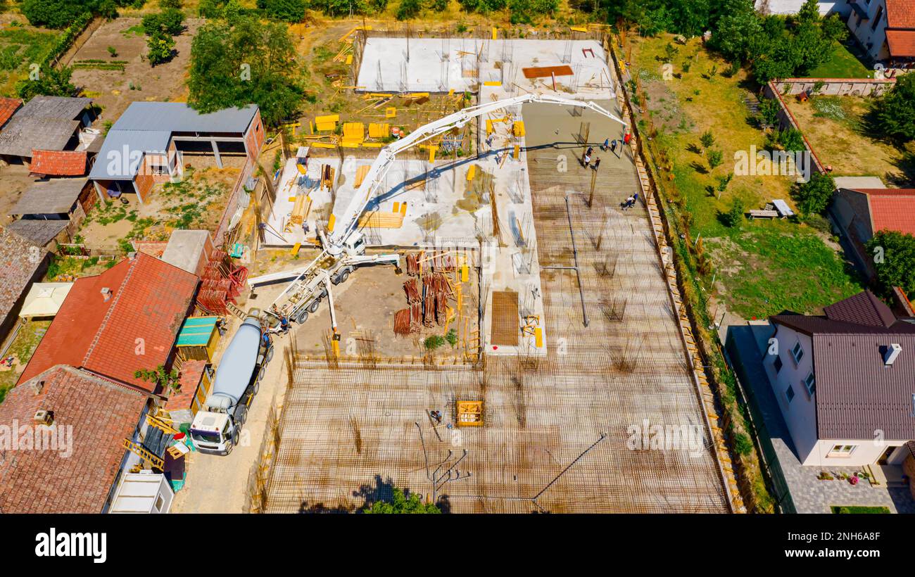 Aerial view construction site, mixer truck pouring concrete into pump ...