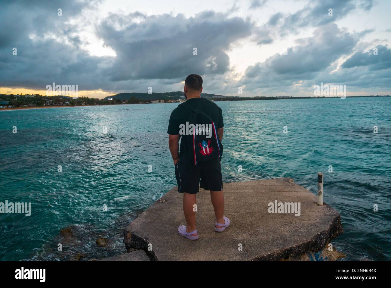 Puerto Rico man standing watching sunset at Luquillo beach Puerto Rico ...