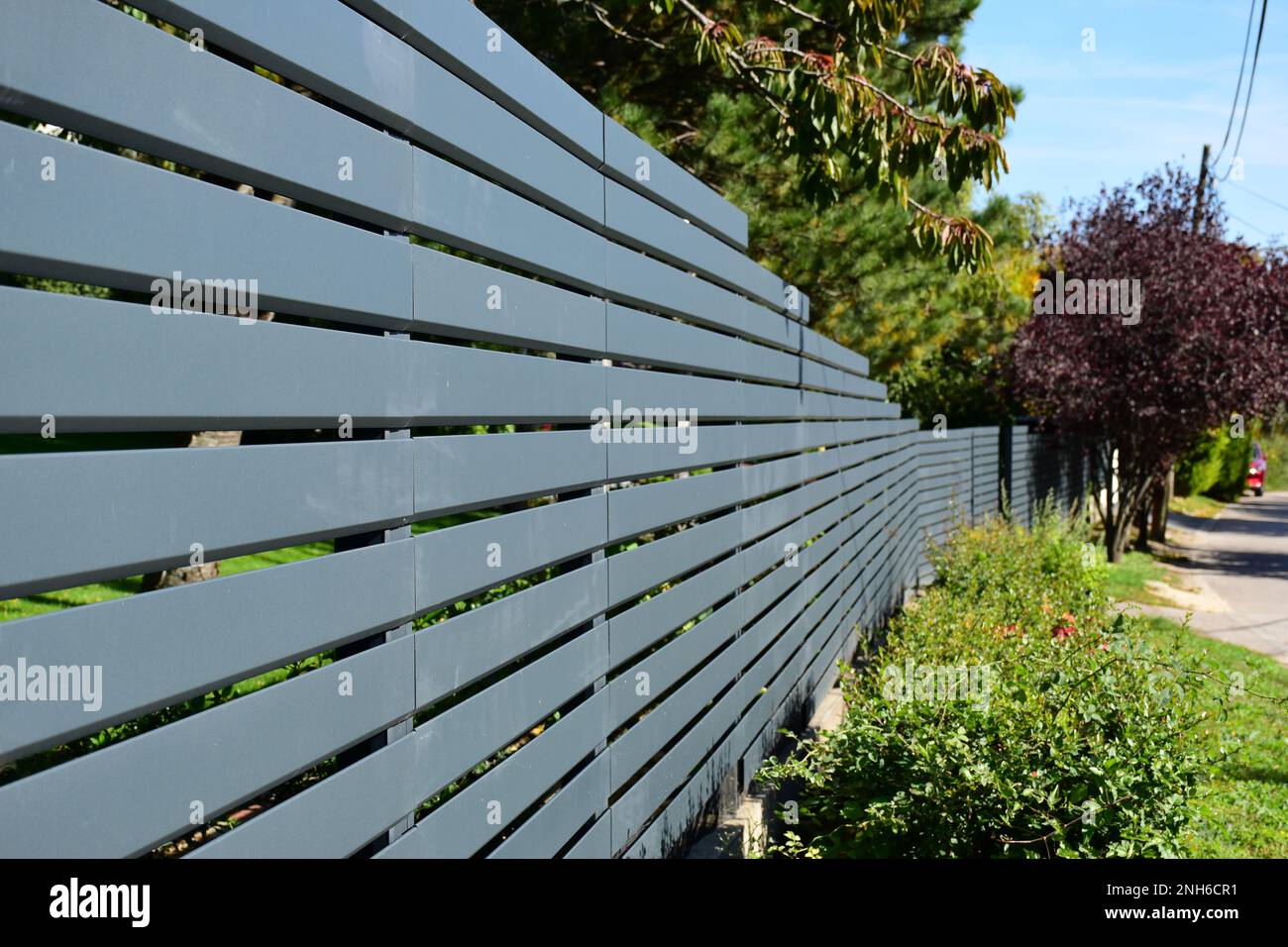 horizontal gray metal fence in diminishing perspective. property safety ...