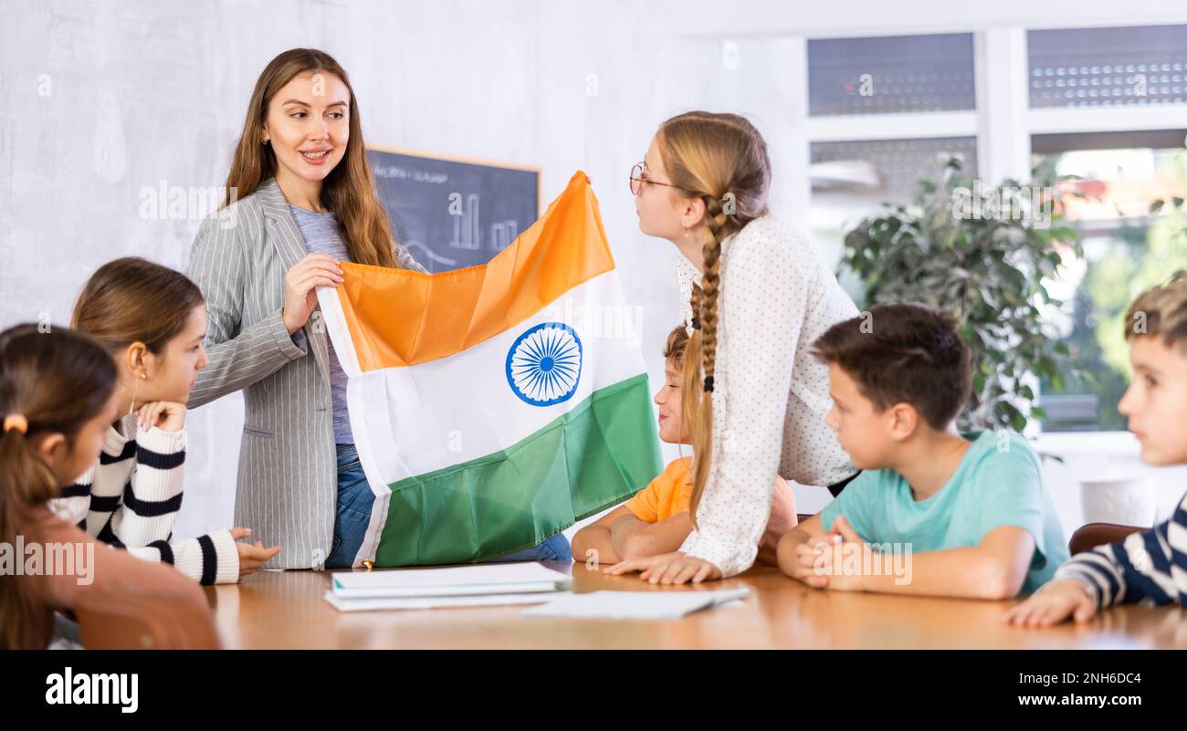 Female teacher working with students in school class, talking about ...