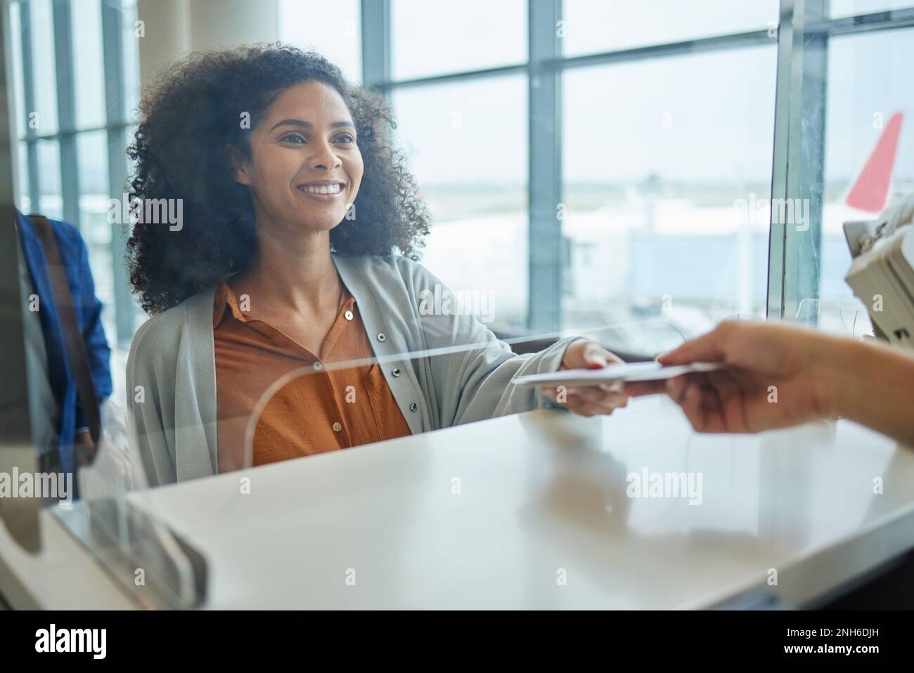 Glass window, ticket check and black woman at airport counter with ...