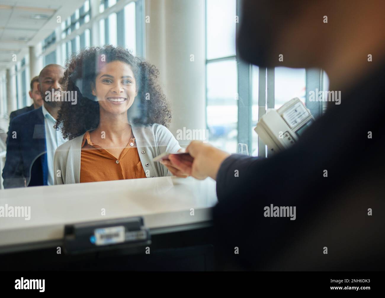 Black woman, ticket check and airport counter with a paper for travel ...