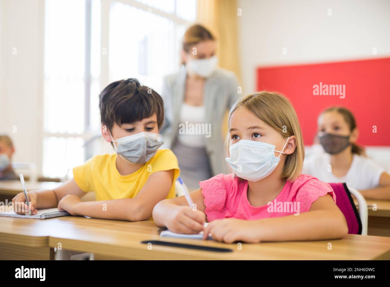 Kid in mask cheating during test Stock Photo - Alamy