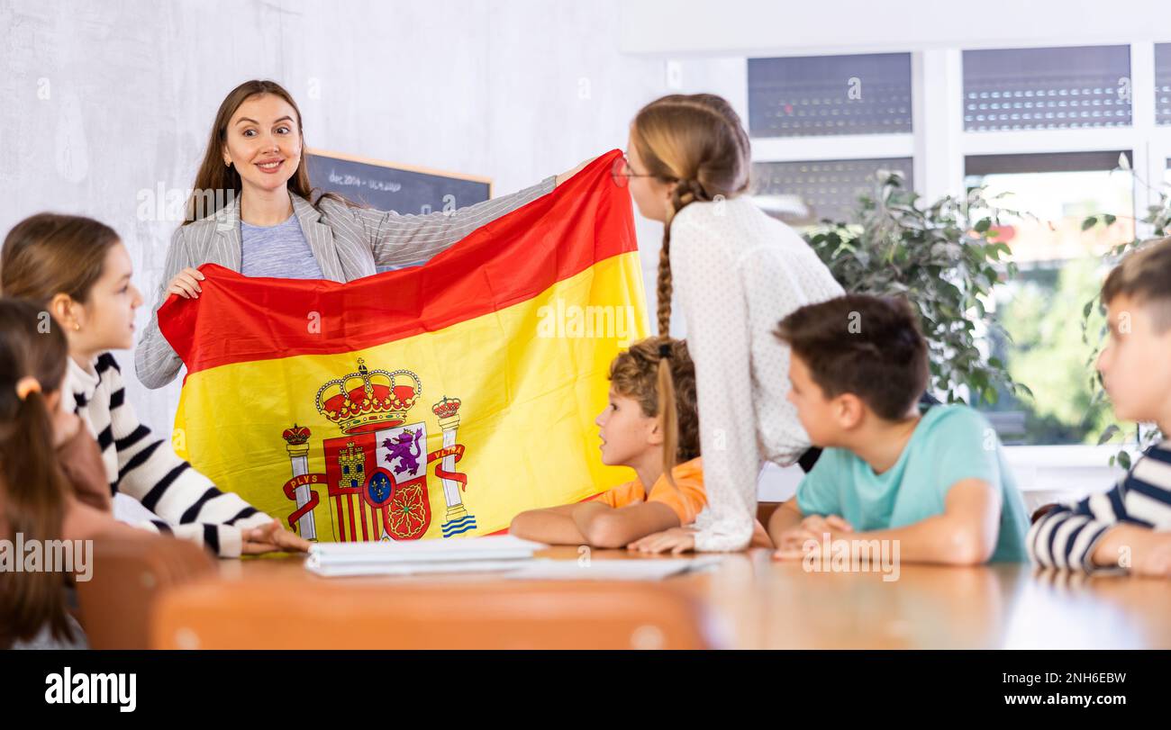 Teacher showing Spain flag to group of schoolchildren Stock Photo - Alamy