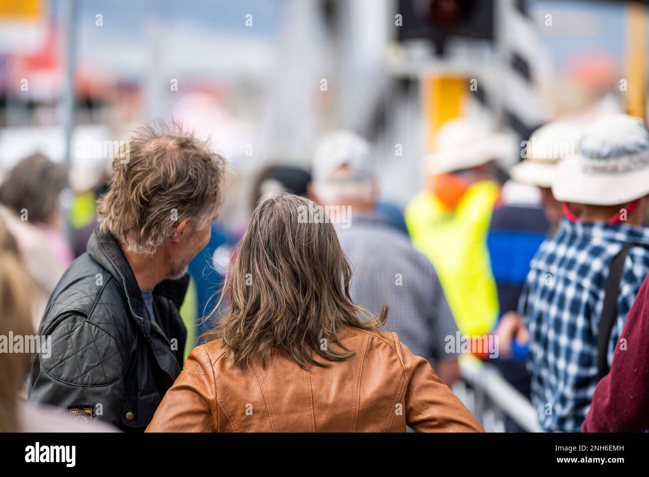 crowd of old people watching an event of tall ships outside in summer ...