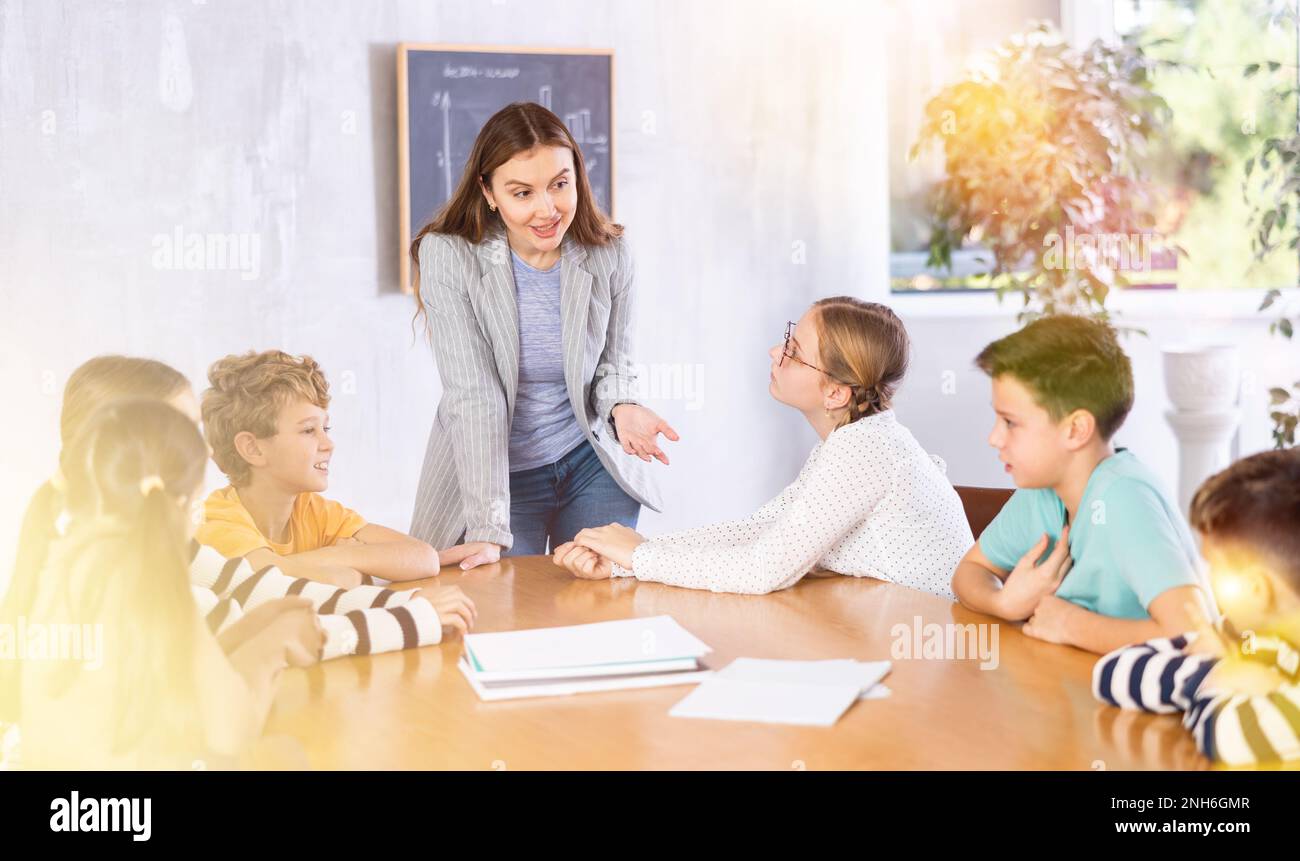 Portrait of female teacher giving lesson to children in school class ...