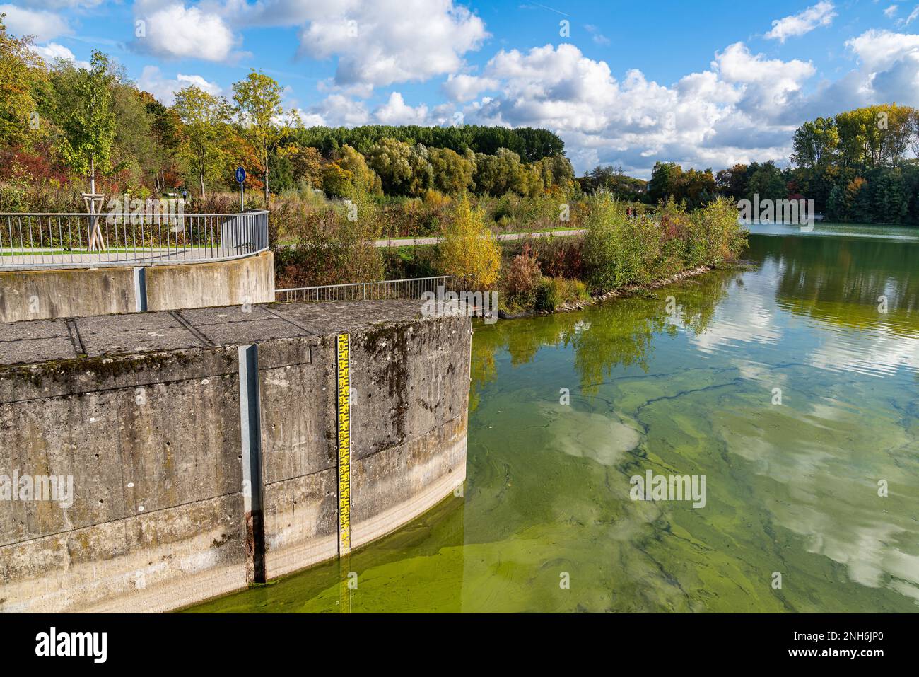 A ruler indicating the level of water in a pond. Autumn landscape under ...