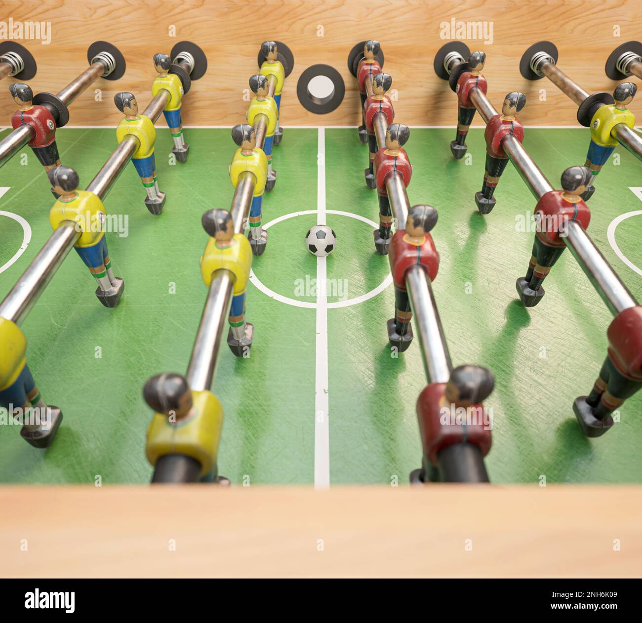 A vintage wooden foosball table with detailed metal player figurines in ...