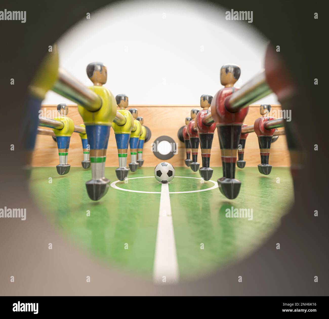 A vintage wooden foosball table with detailed metal player figurines in ...