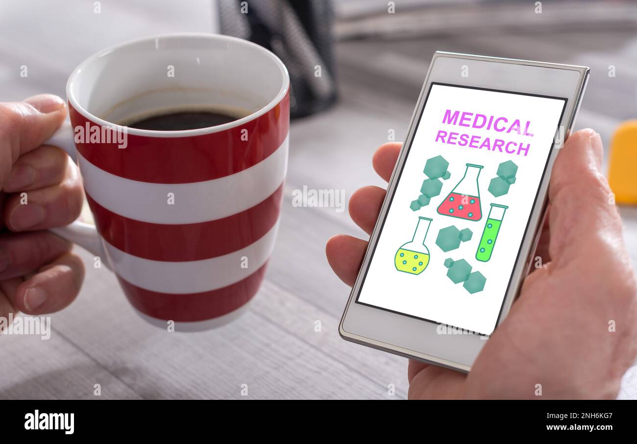 Male hand holding a smartphone with medical research concept Stock ...