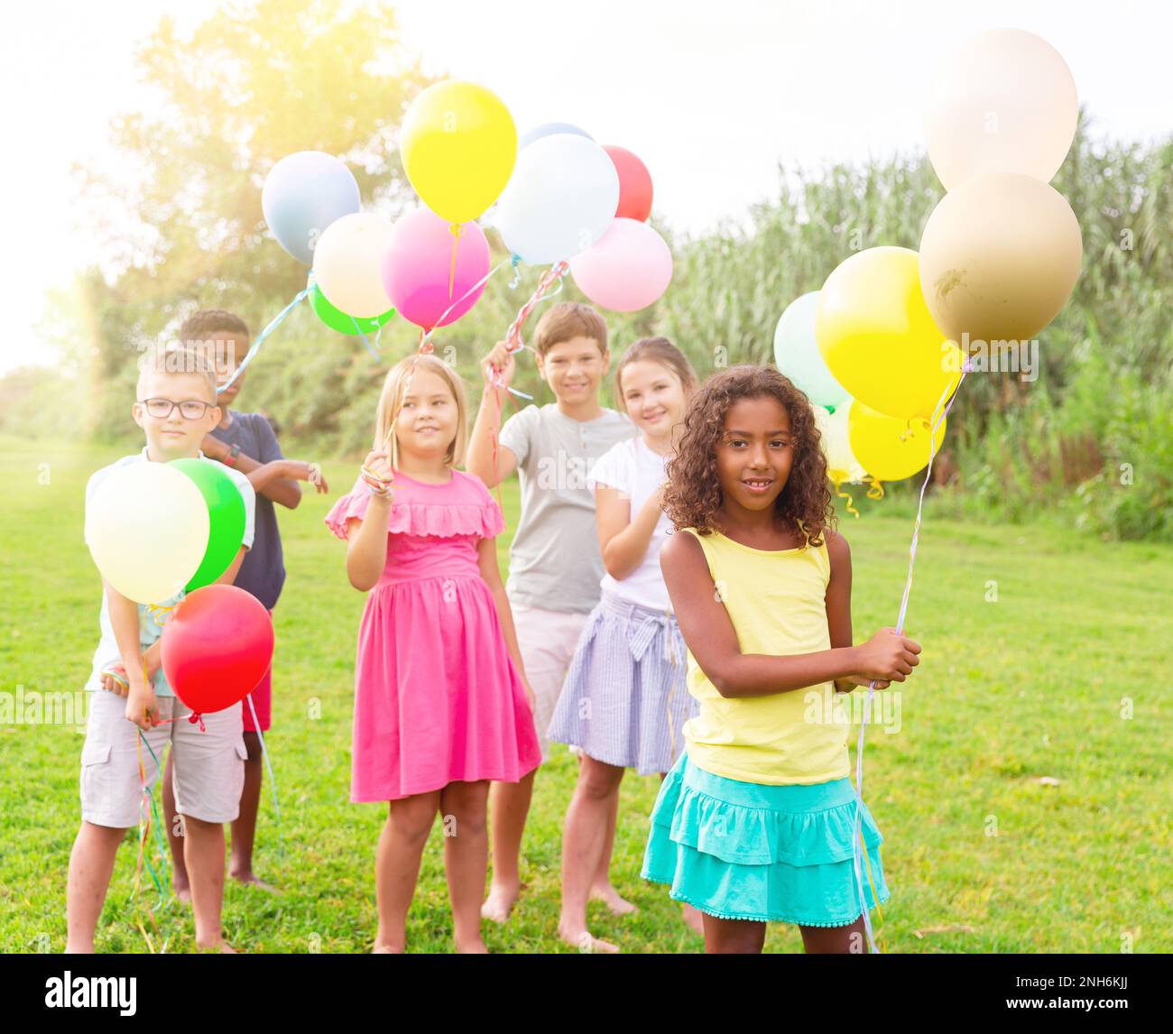 Children with balloons on field Stock Photo - Alamy