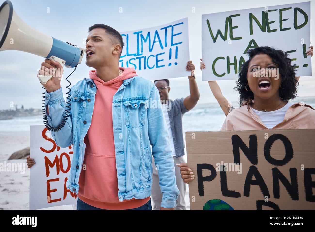 Protest, environment and climate change with man and megaphone on beach ...
