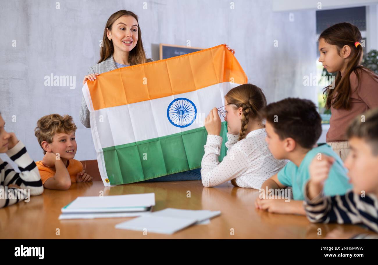 Female teacher working with students in school class, talking about ...