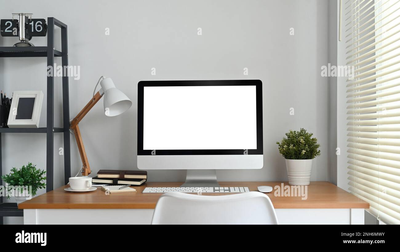 Modern home office interior with blank computer screen on wooden desk ...