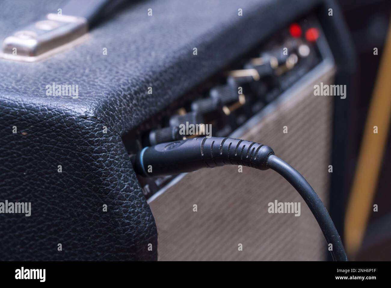 Plug jack with cable plugged into a black guitar combo amplifier Stock ...