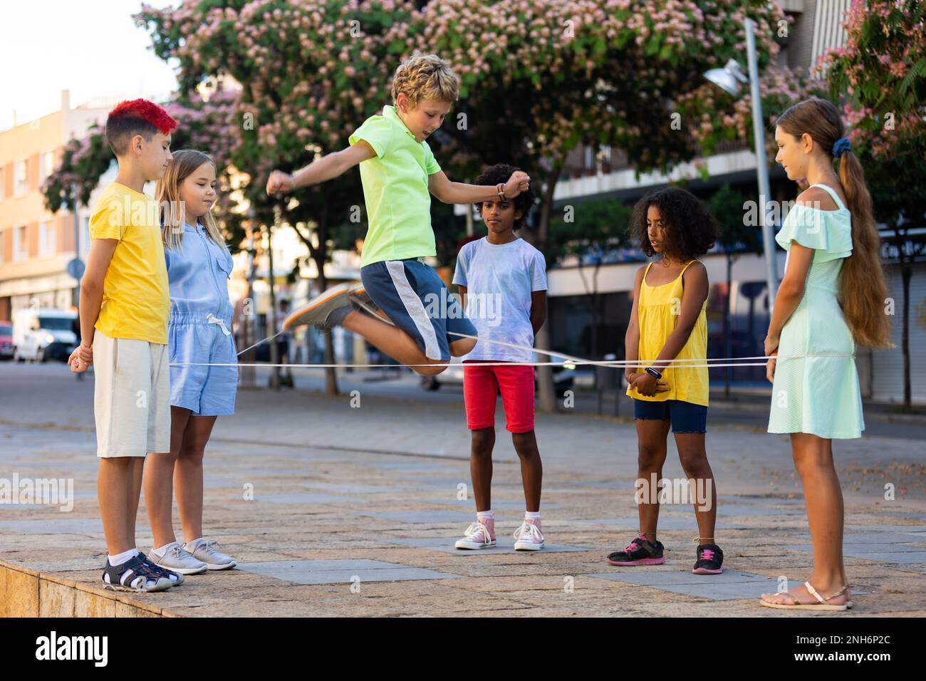 Happy preteen kids skipping on chinese jump rope Stock Photo - Alamy
