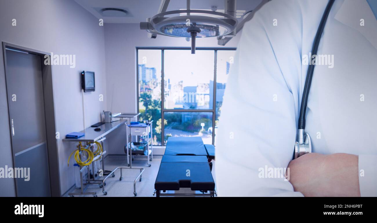 Mid section of male doctor with arms crossed against operation theatre ...