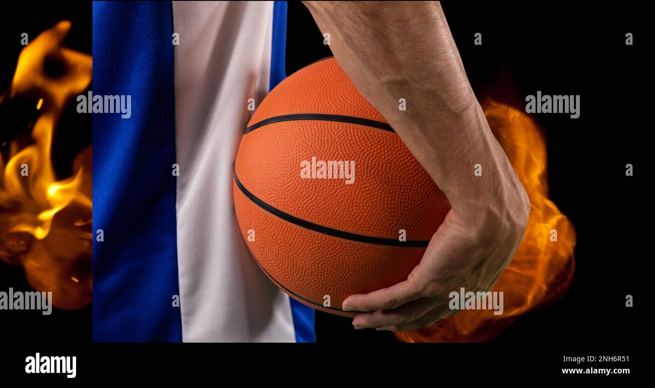 Composition of midsection of male basketball player holding ball over ...