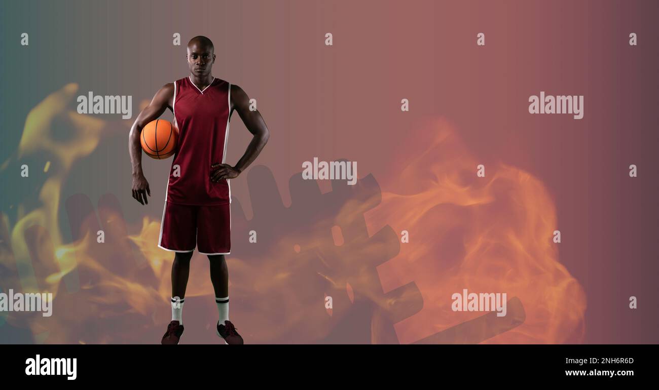 Composition of male basketball player standing holding ball, over smoke ...