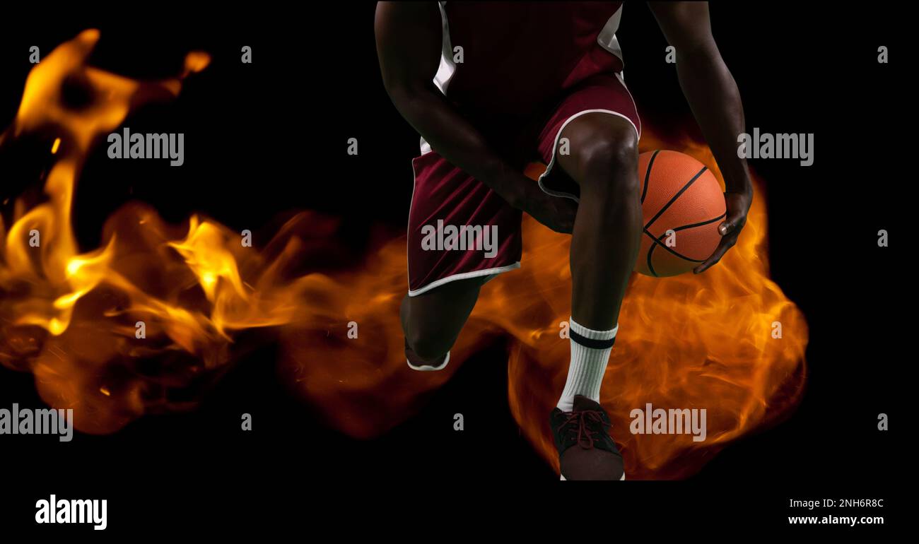 Composition of low section of male basketball player holding ball over ...
