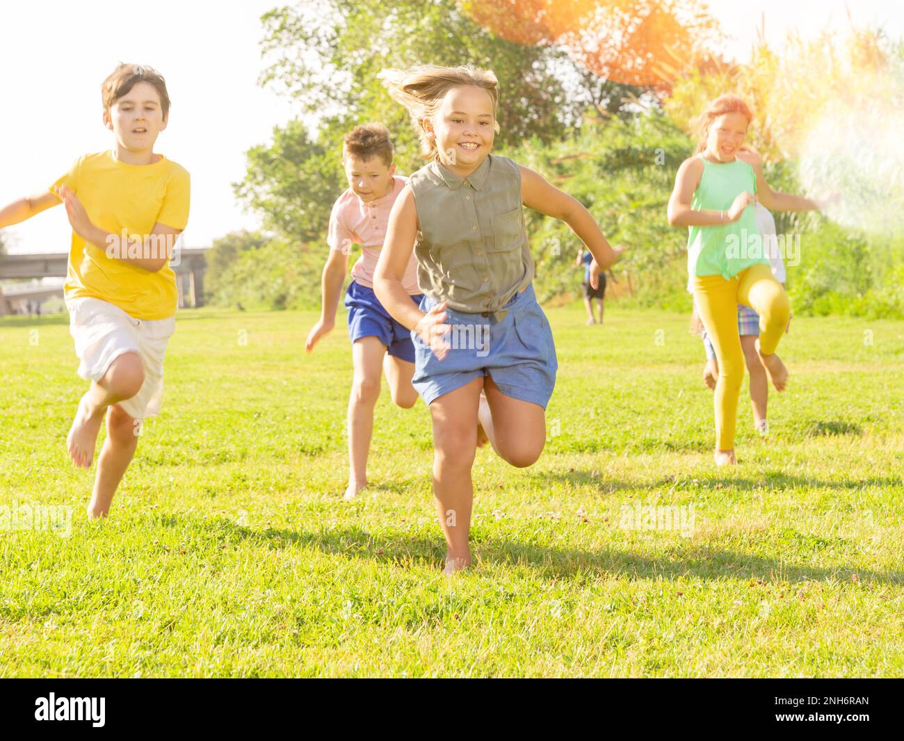 Group of five happy children jogging in a park Stock Photo - Alamy