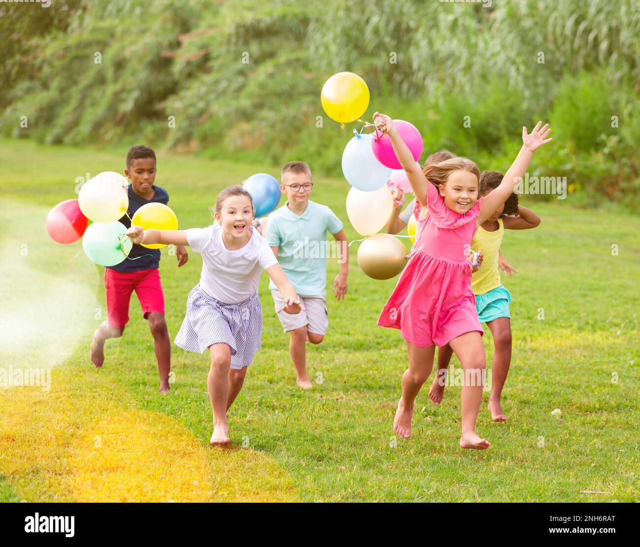 Kids with balloons running through field Stock Photo - Alamy