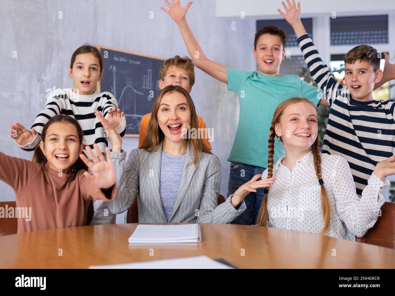 Portrait of happy preteens young learners and their female teacher ...