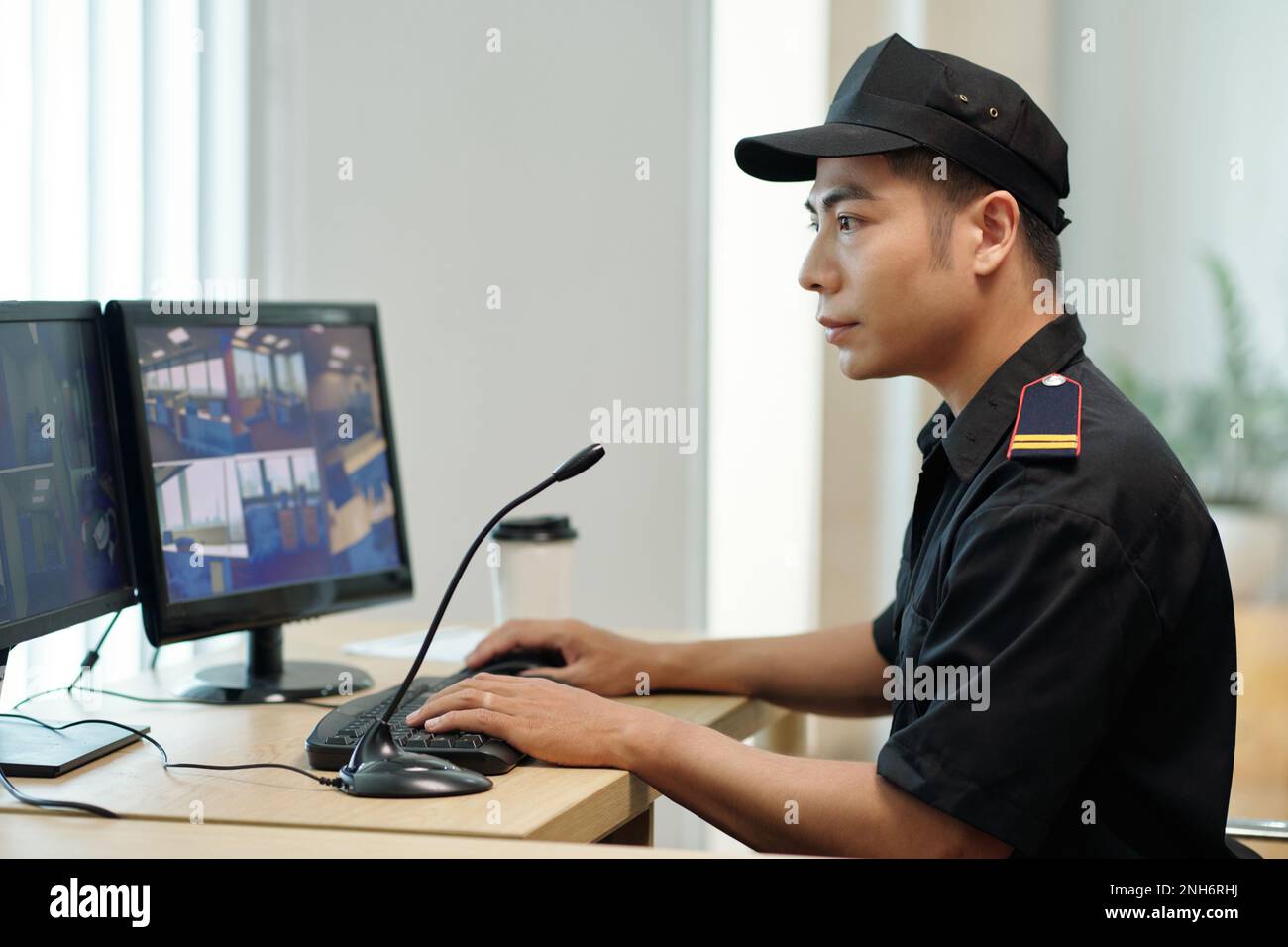 Security guard watching videos on computer screen Stock Photo - Alamy