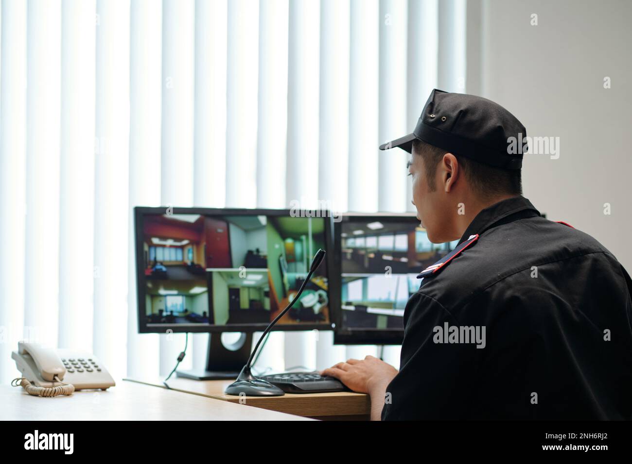 Security guard speaking in microphone when noticing suspicious activity ...