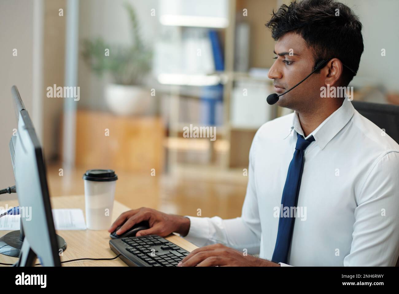 Security officer working at office desk and speaking in microphone ...