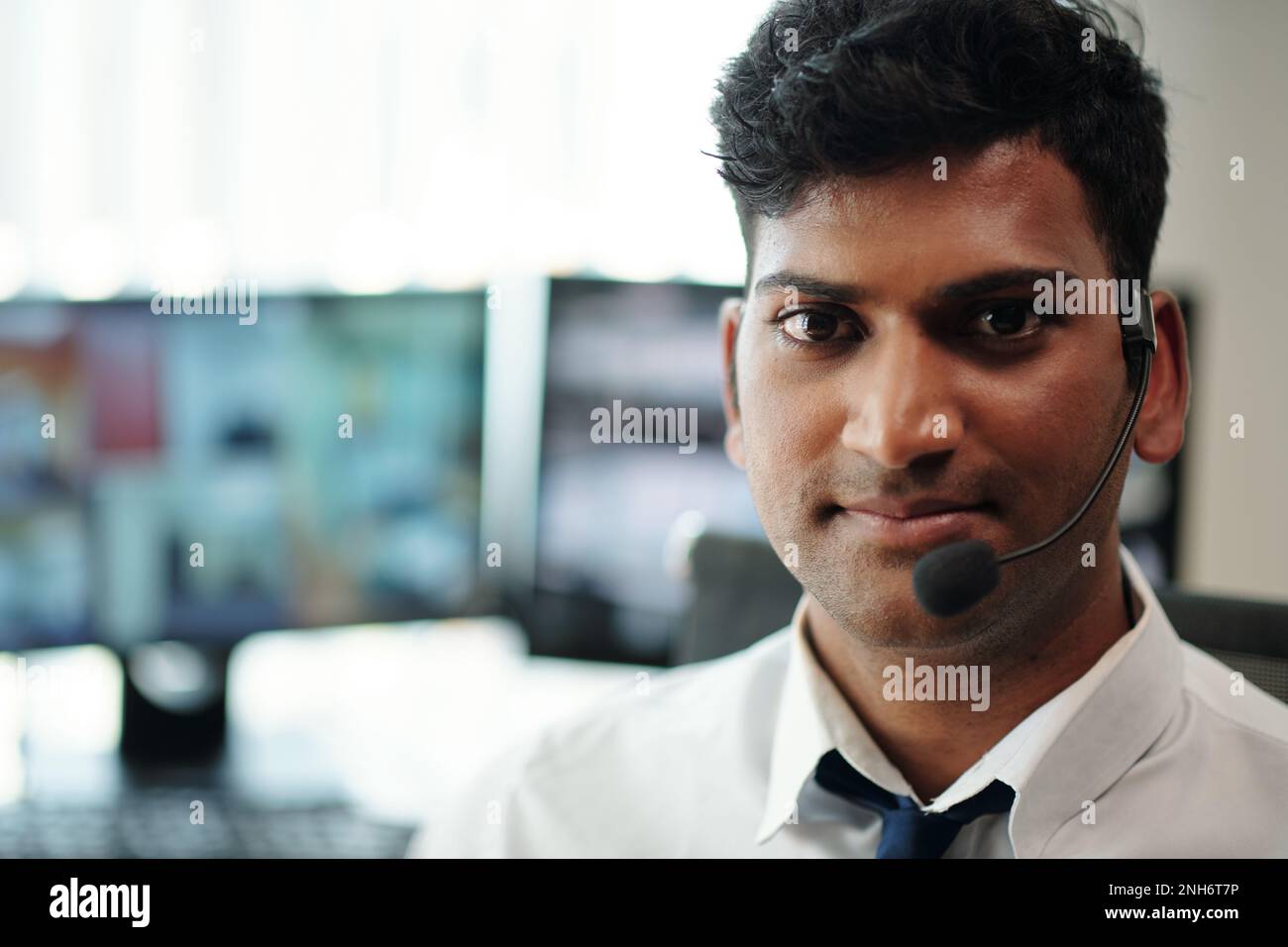 Portrait of smiling security manager standing in surveillance room ...