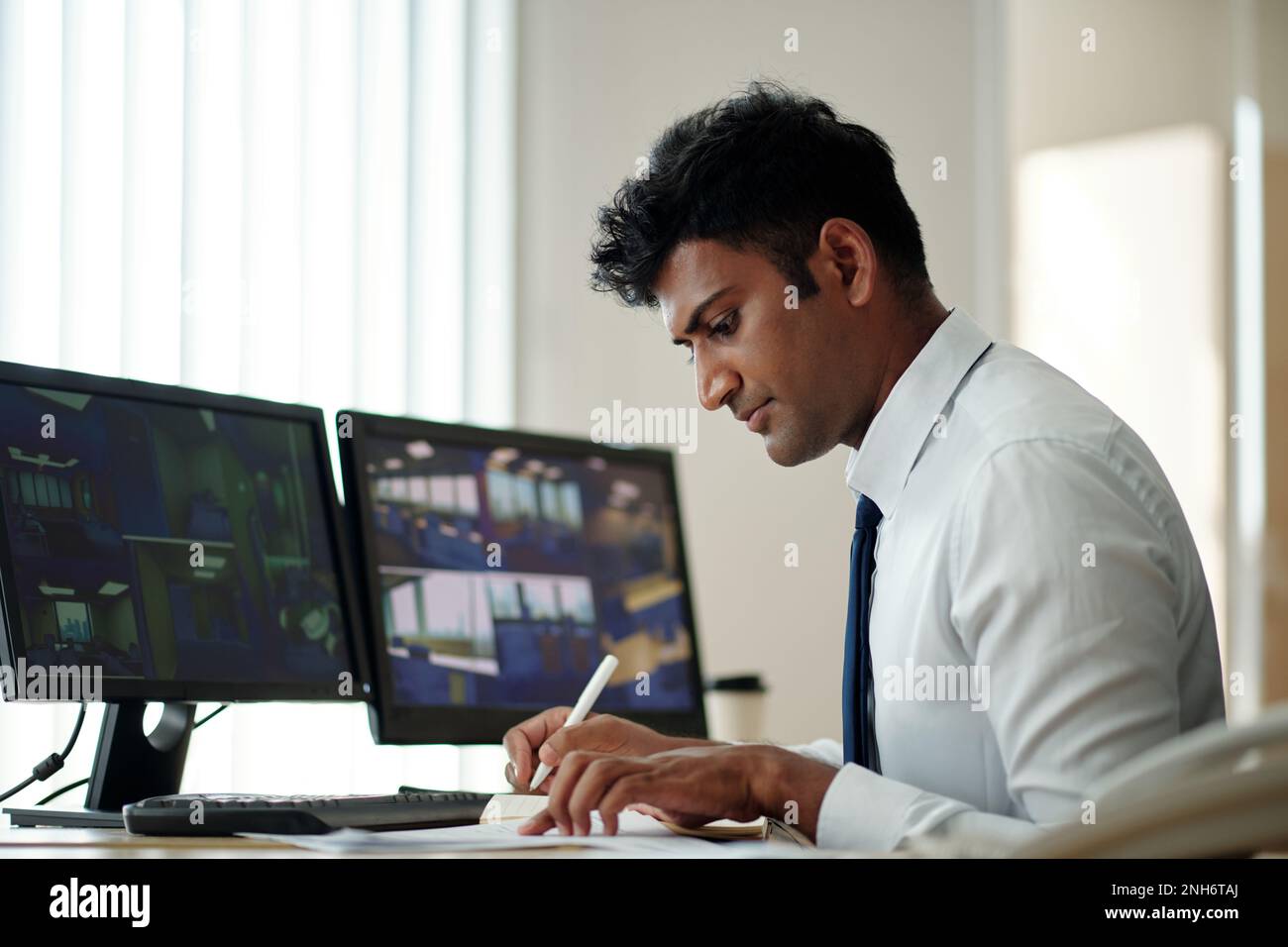 Security guard working in surveillance room and filling documents Stock ...