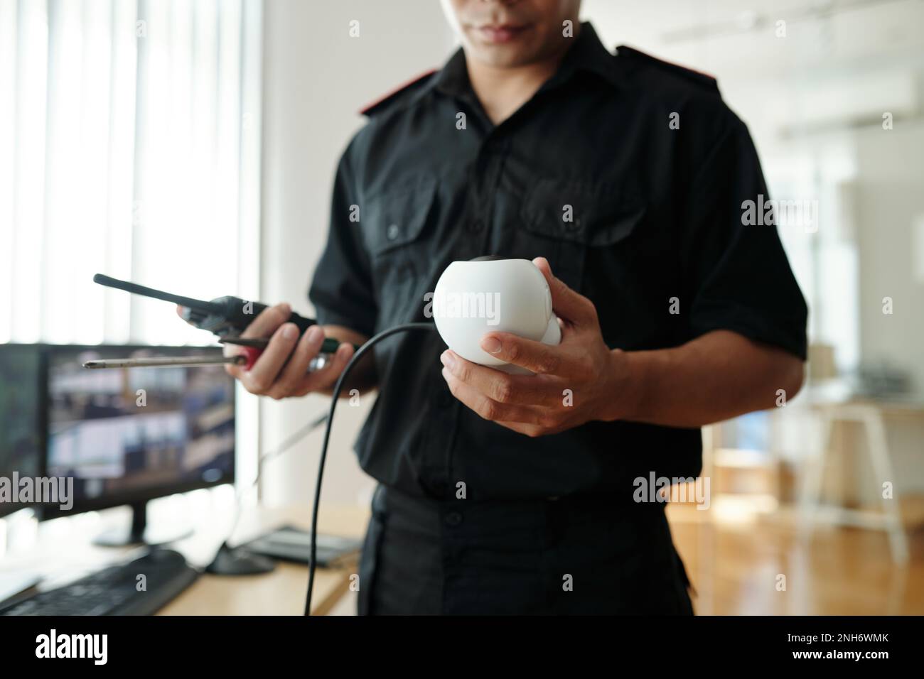 Security guard installing new surveillance camera in office Stock Photo ...