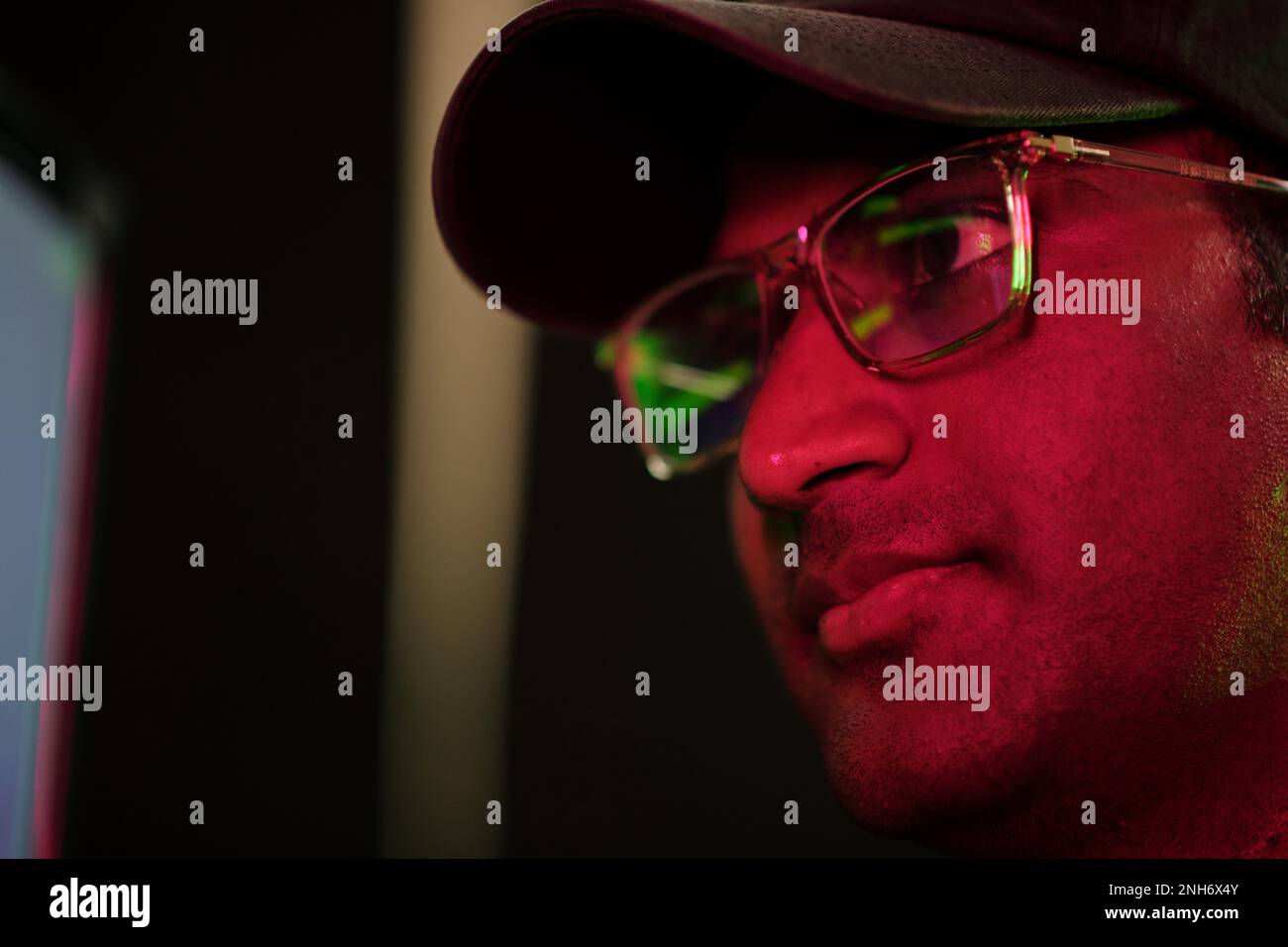 Face of cyber criminal in cap and glasses stealing user personal data ...