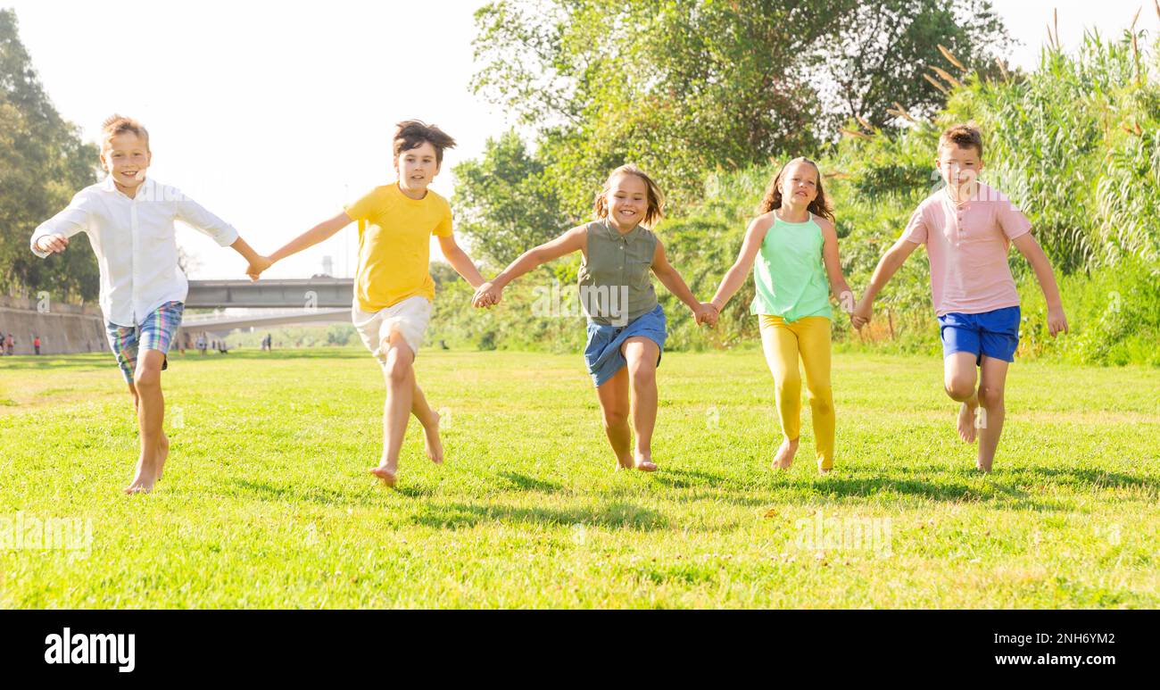 Group of five happy children jogging in a park Stock Photo - Alamy