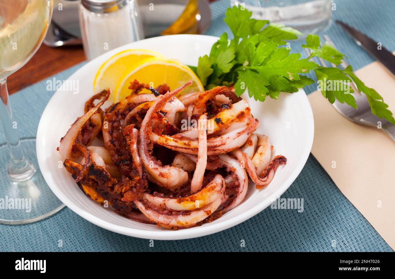 Roasted squid legs with lemon Stock Photo - Alamy