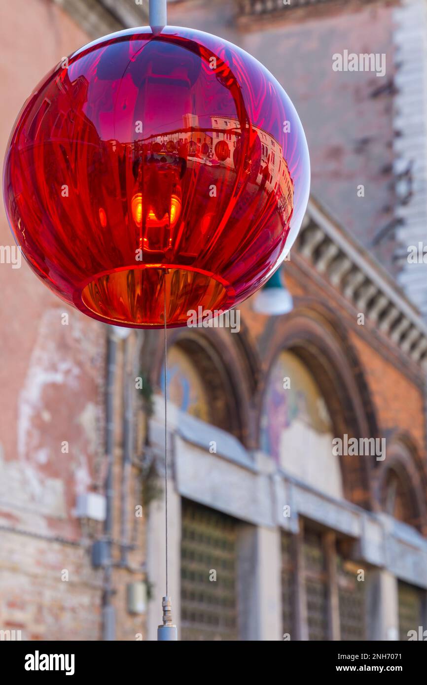 Close up of red Murano glass light with reflections hanging at Murano, Venice, Italy in February ...