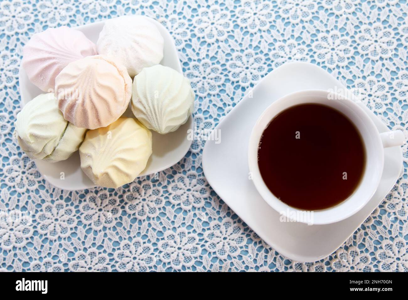 Traditional delicious brewed tea in a cup and air marshmallows lie on ...