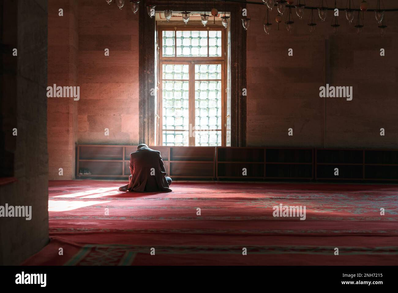 Ramadan or islamic concept photo. A muslim man sitting and praying in ...