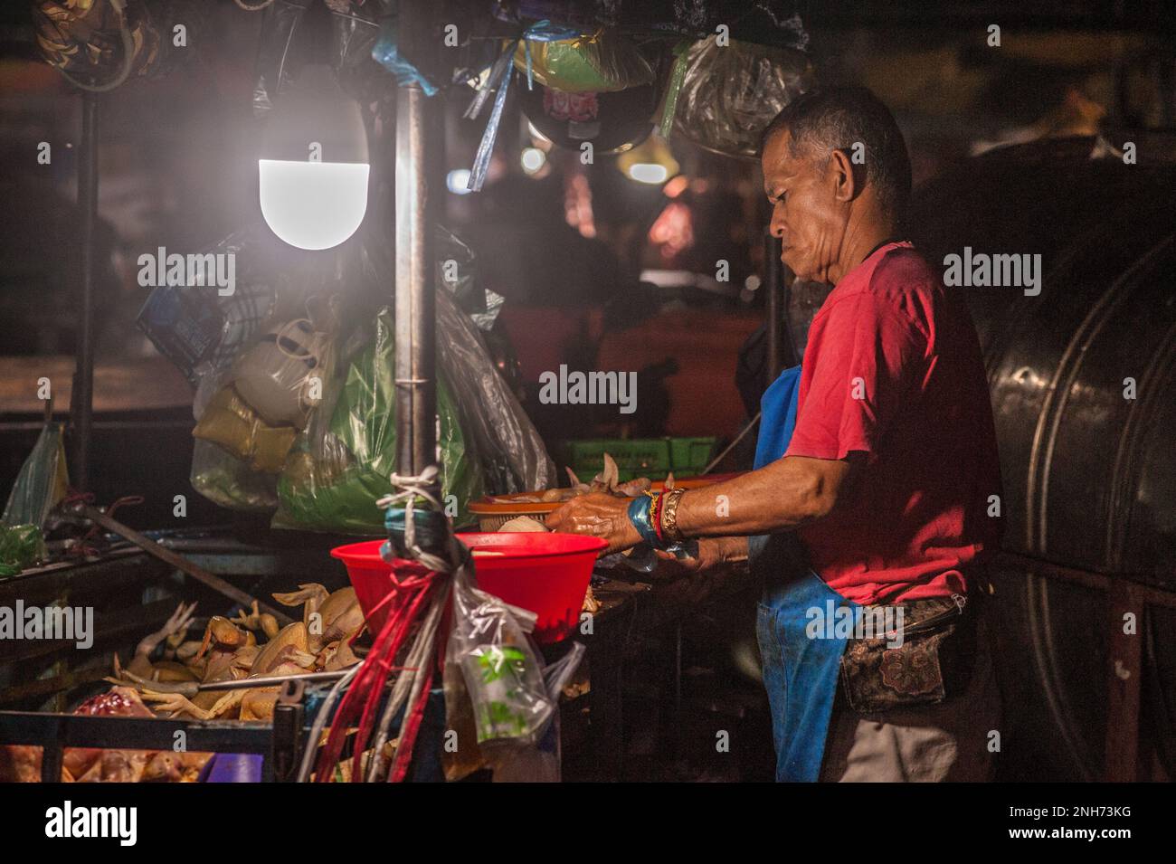 A Cambodian butcher prepares raw chicken at the main wholesale ...
