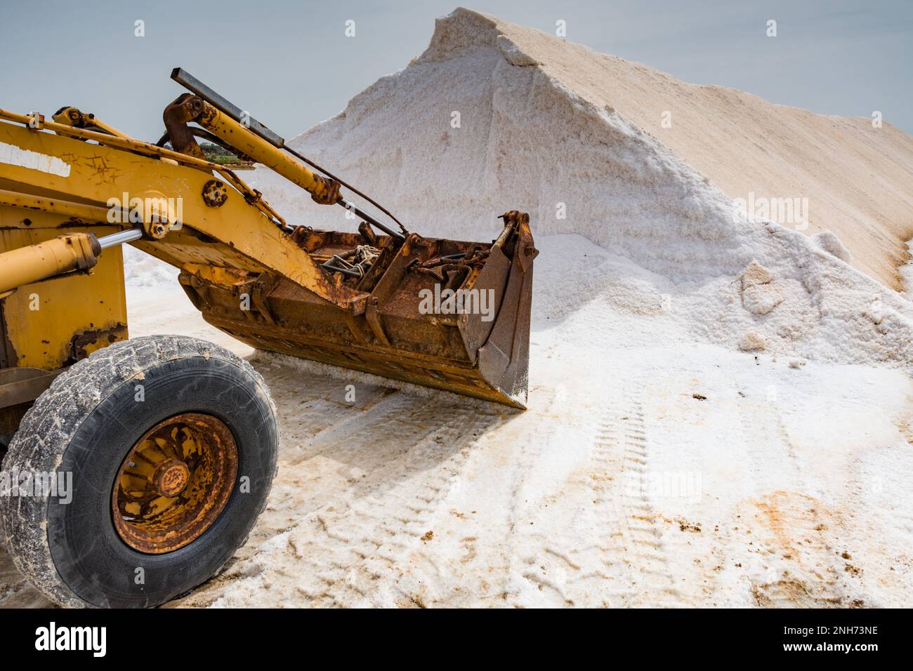 Bulldozers working on piles of salt, salt pans of Trapani Stock Photo ...