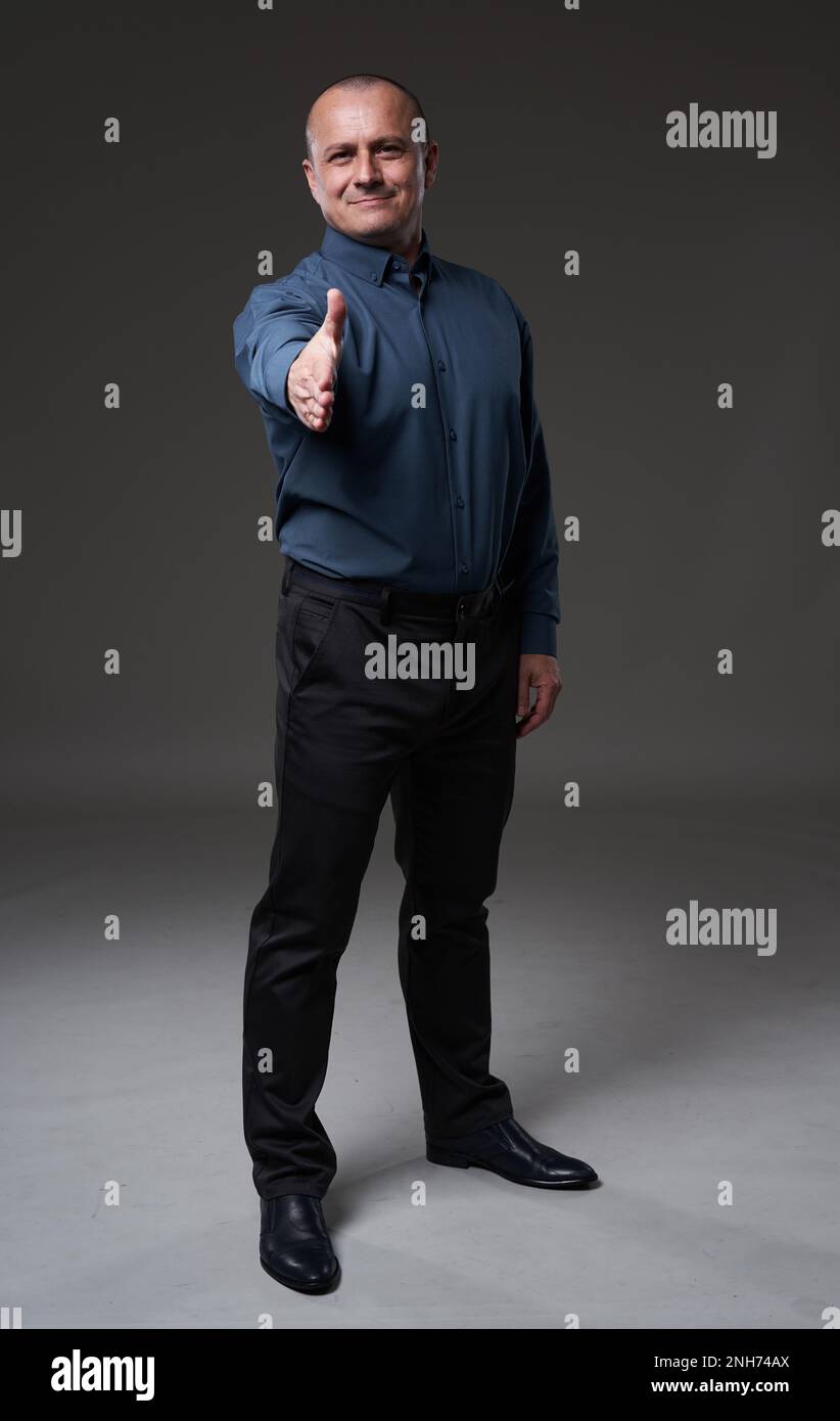 Confident smiling mature business man greeting the viewer with a ...