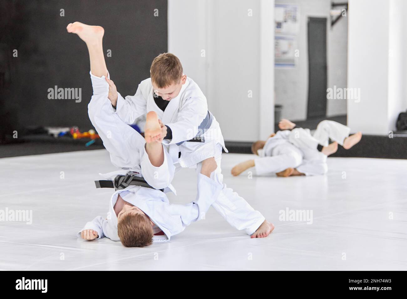 Boys, children in white kimono training, practising judo, jiu-jitsu exercises indoors Stock ...