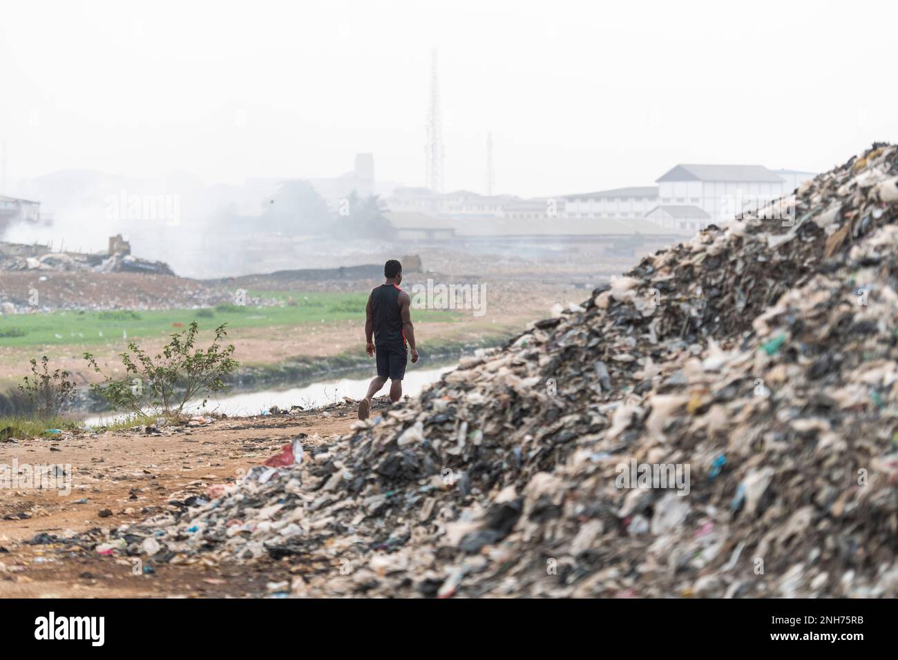 Accra, Ghana. 21st Feb, 2023. A man walks on a garbage dump where ...