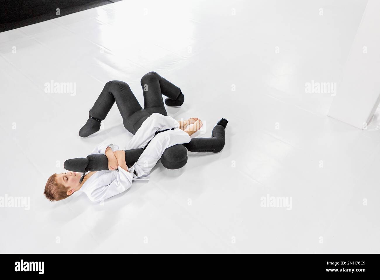 Little boy, child in white kimono practising, training judo, jiu-jitsu exercises with sport ...